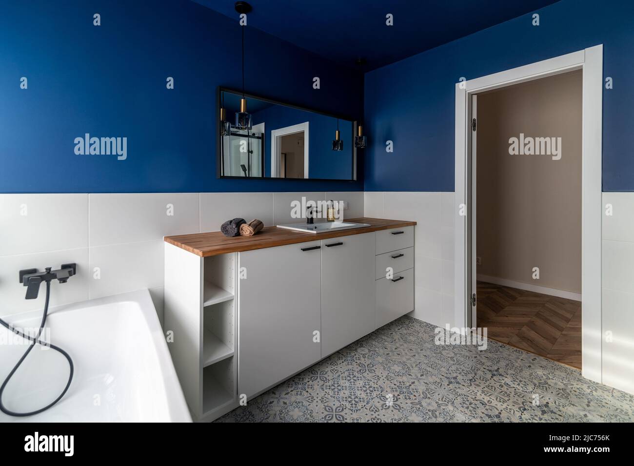 Modern bathroom with blue walls, white furniture Stock Photo - Alamy
