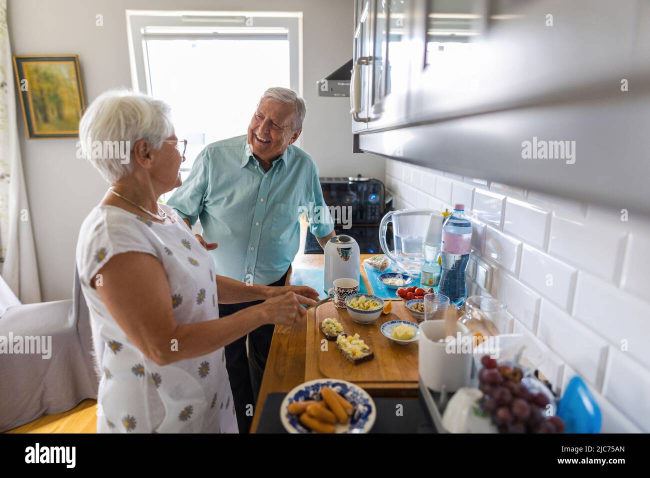Senior couple in a kitchen making breakfast Stock Photo - Alamy