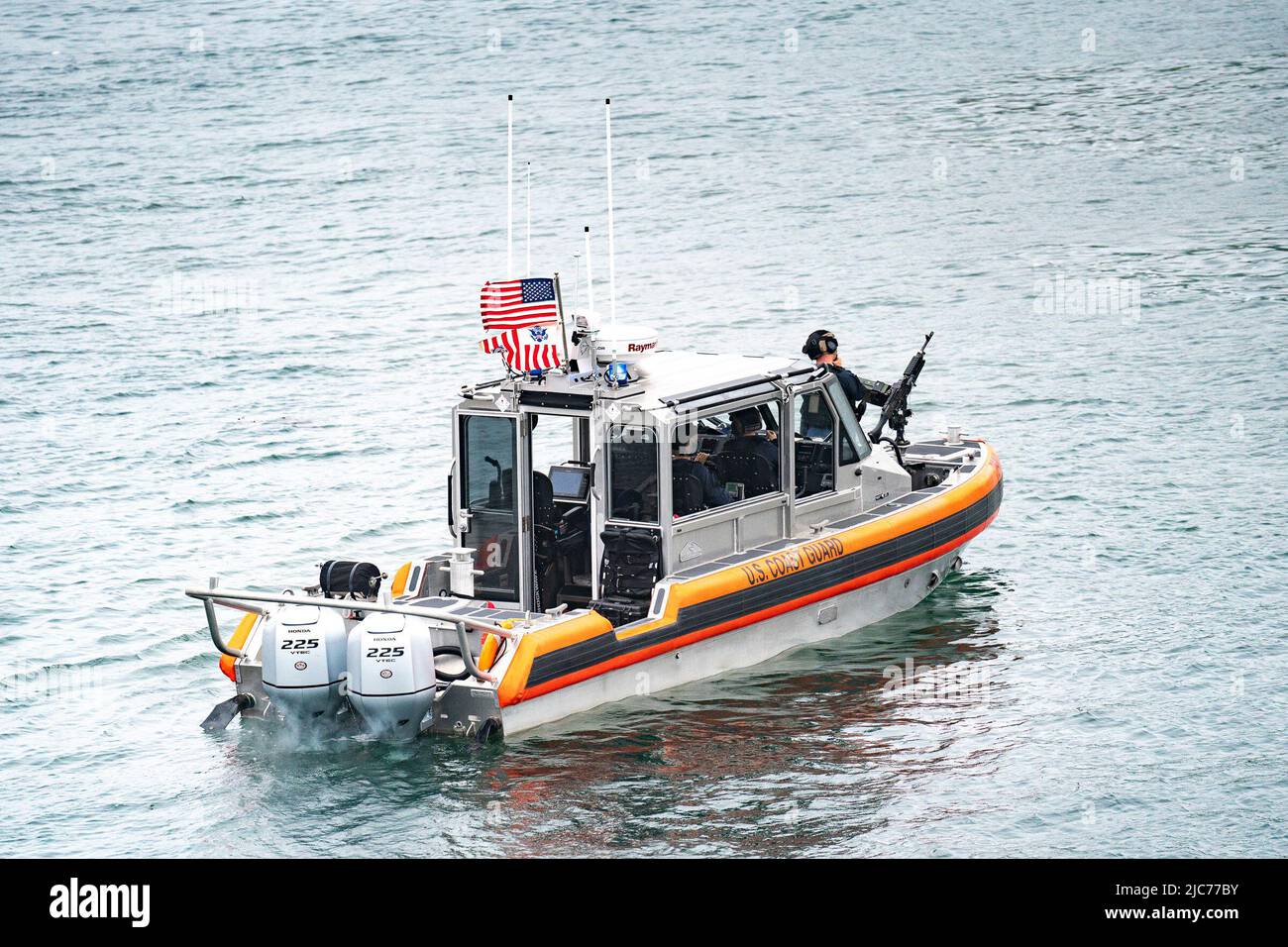 A U.S. Coast Guard vessel patrols the waters outside of the USS Iowa ...