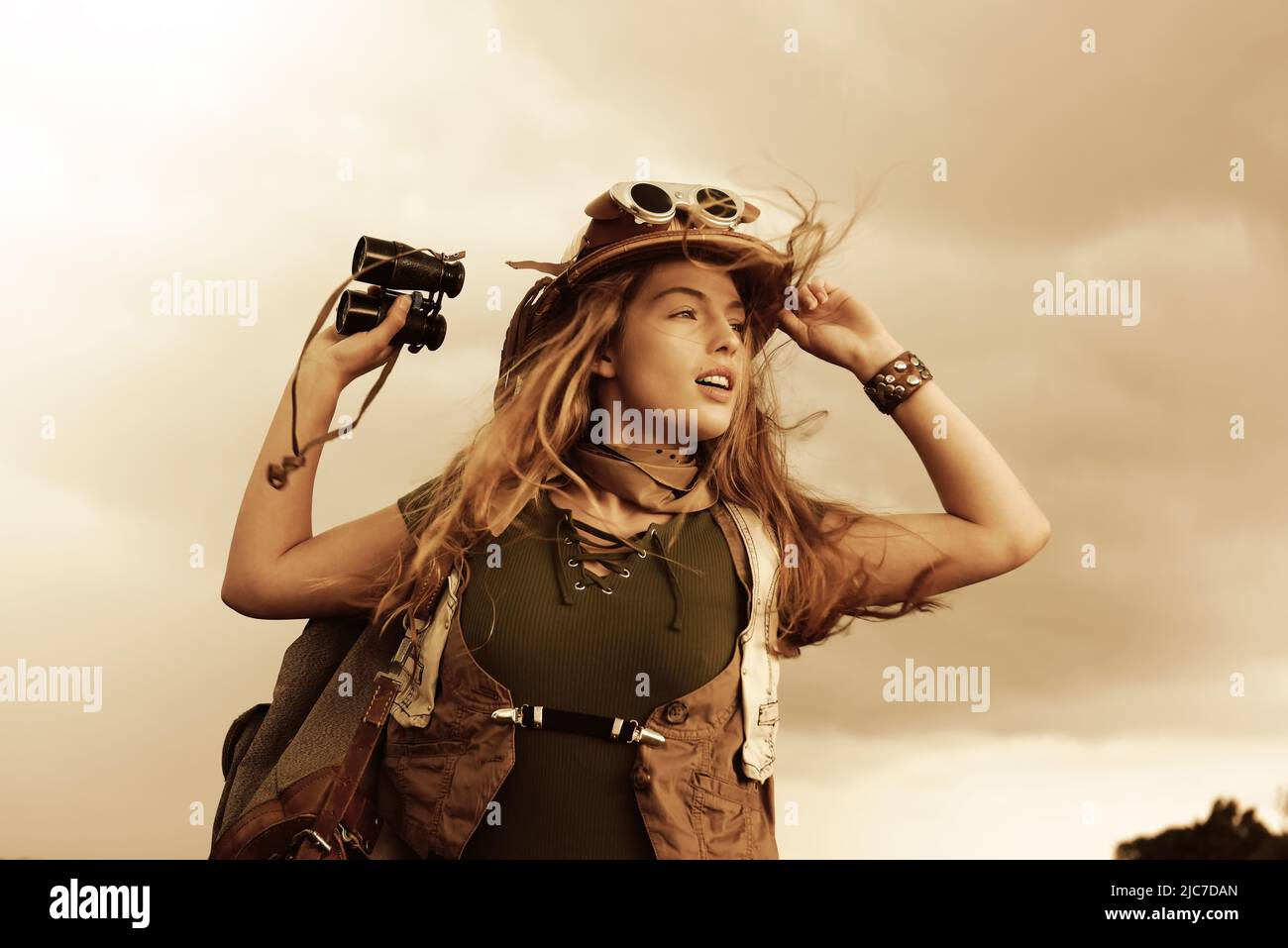 A cheerful young teenage girl dresses up as an explorer. She wears a ...