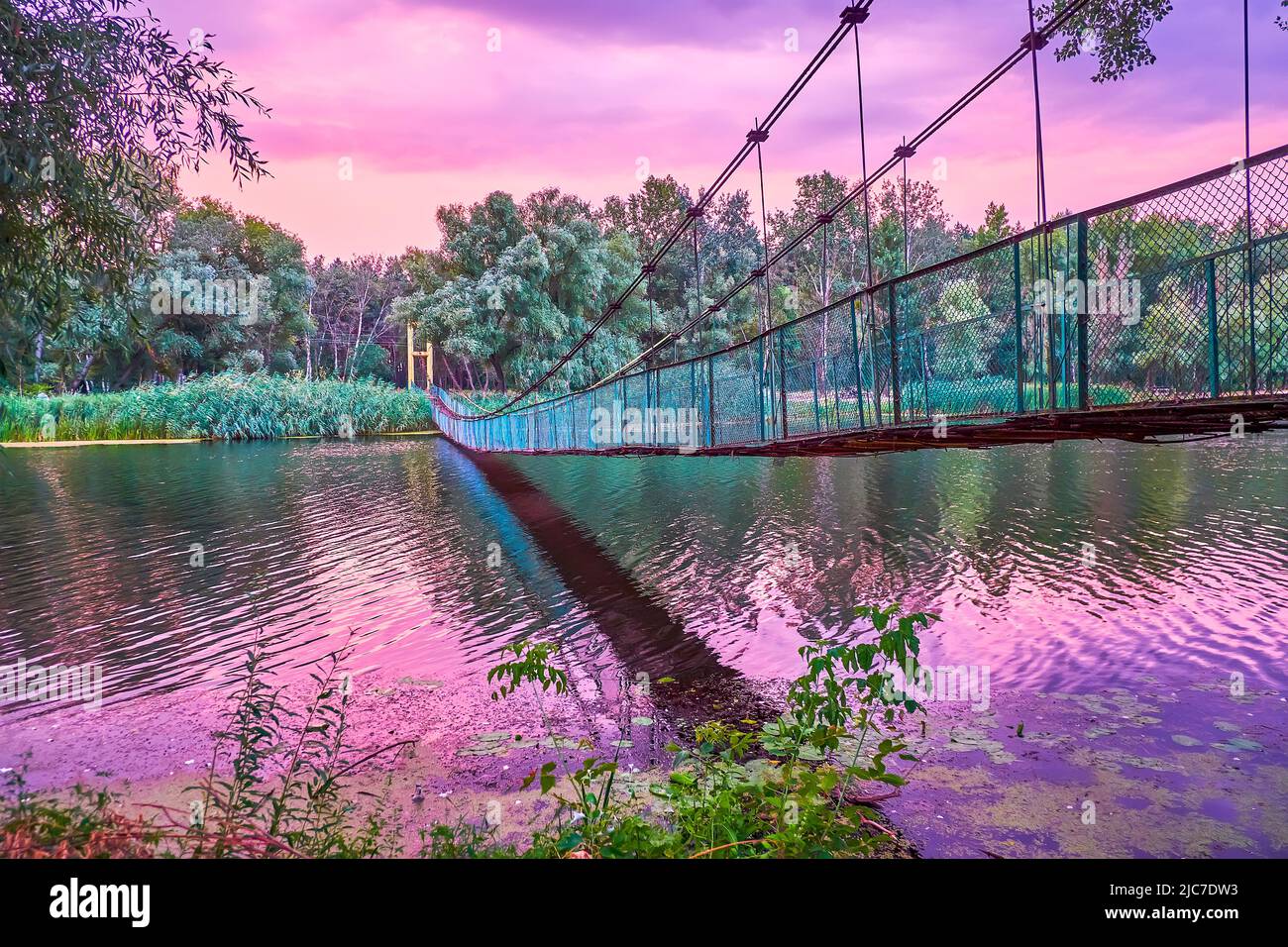 The dusk in Velyka Bahachka village at old suspension bridge above Psel ...