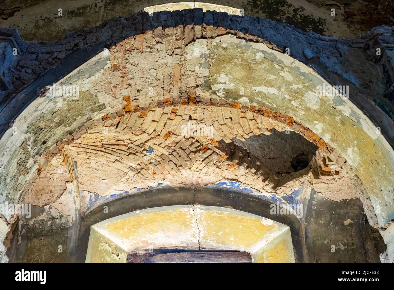 Red brick ceiling in the form of a crypt in an ancient building. Hole ...