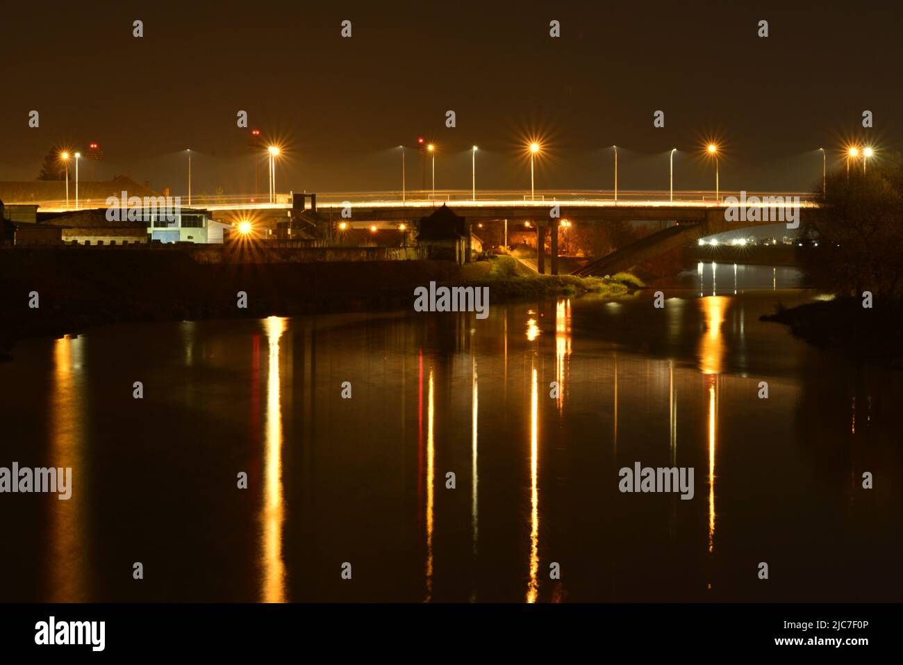 Nightscape with bridge and light reflections on river water Stock Photo ...