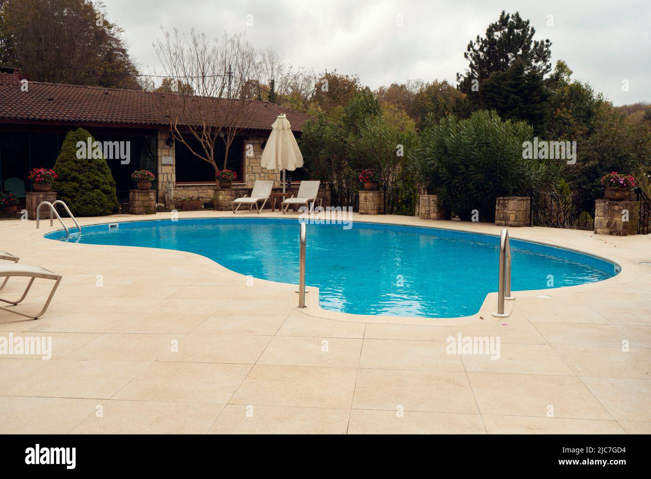 Lovely little pool with sun beds, with a cottage at background ...