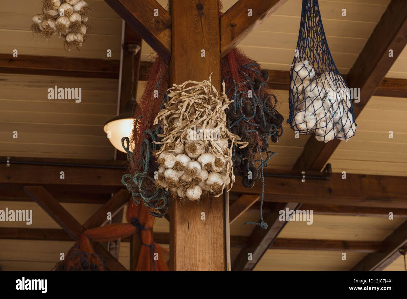 Hanging garlics in a net Stock Photo - Alamy