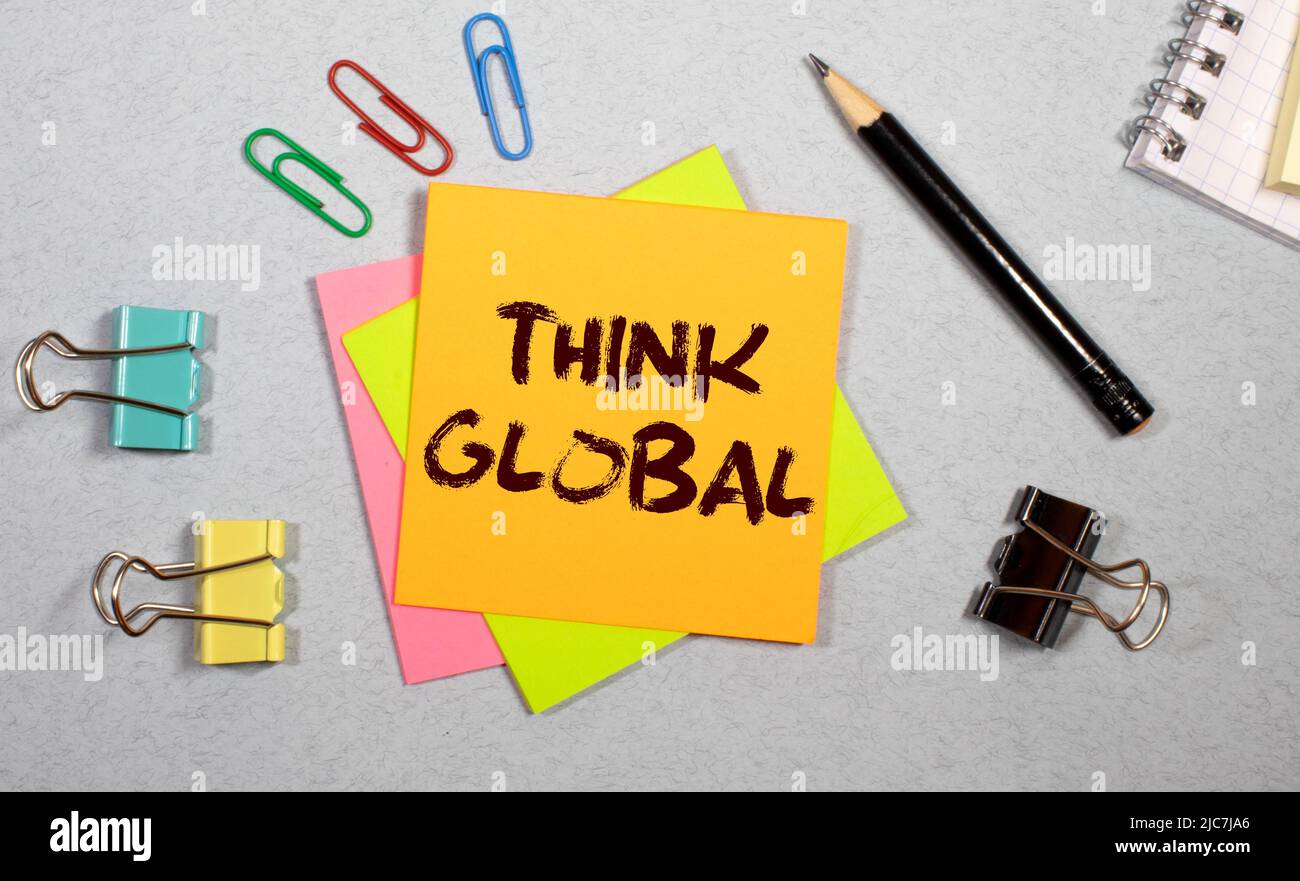 text Think Global on yellow paper Stock Photo - Alamy