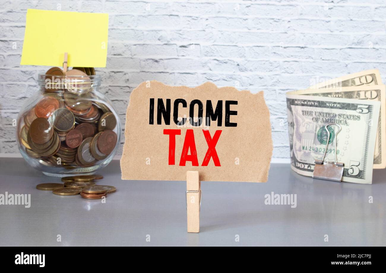 Income Tax text on paper sheet with magnifying glass on chart, dice ...