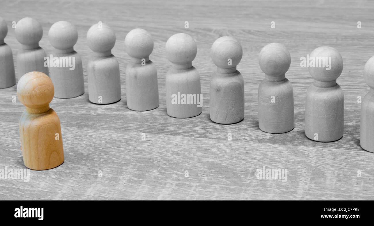 Abstract wooden figures of man and people stand apart from each other ...