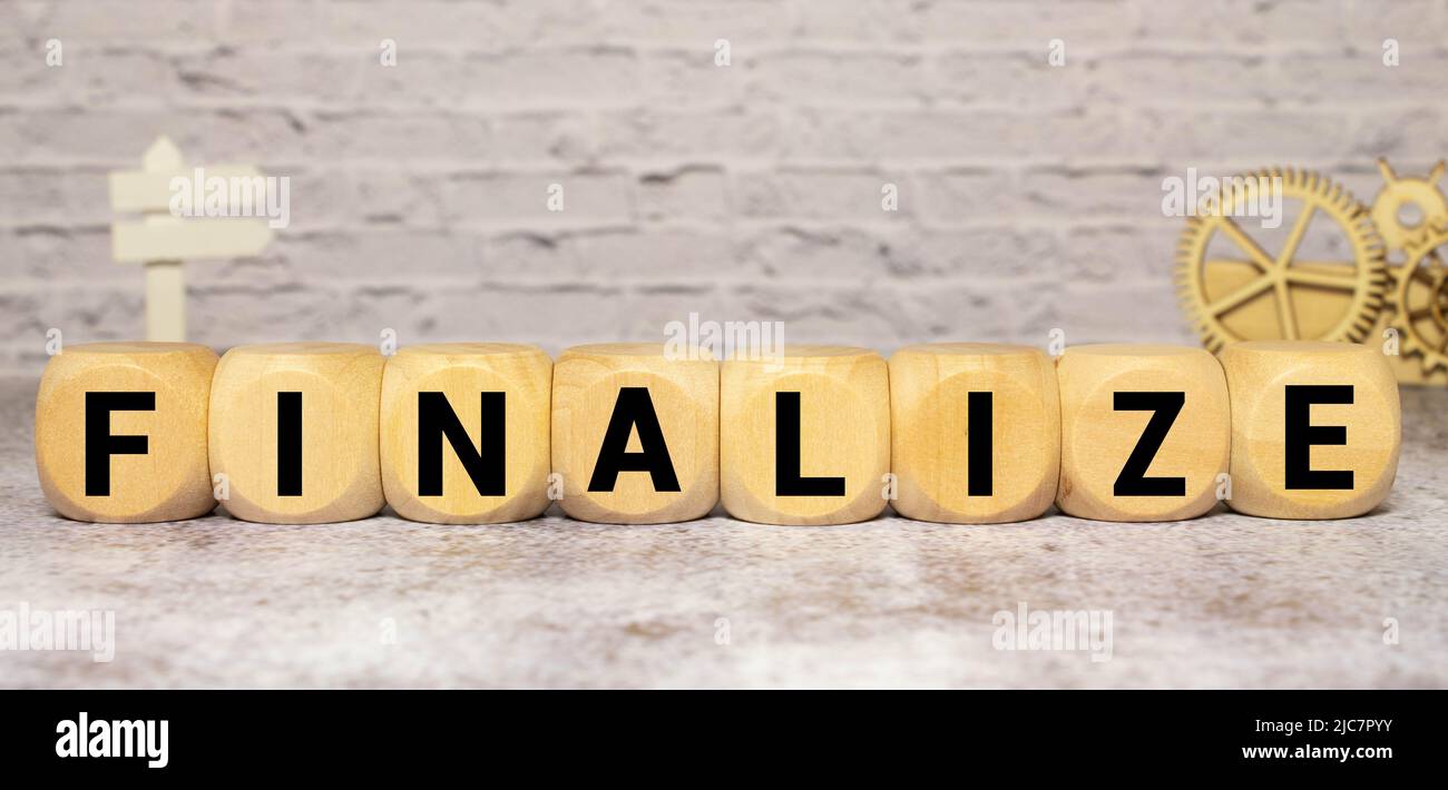 Finishing message word on a wooden cube blocks with blue background ...