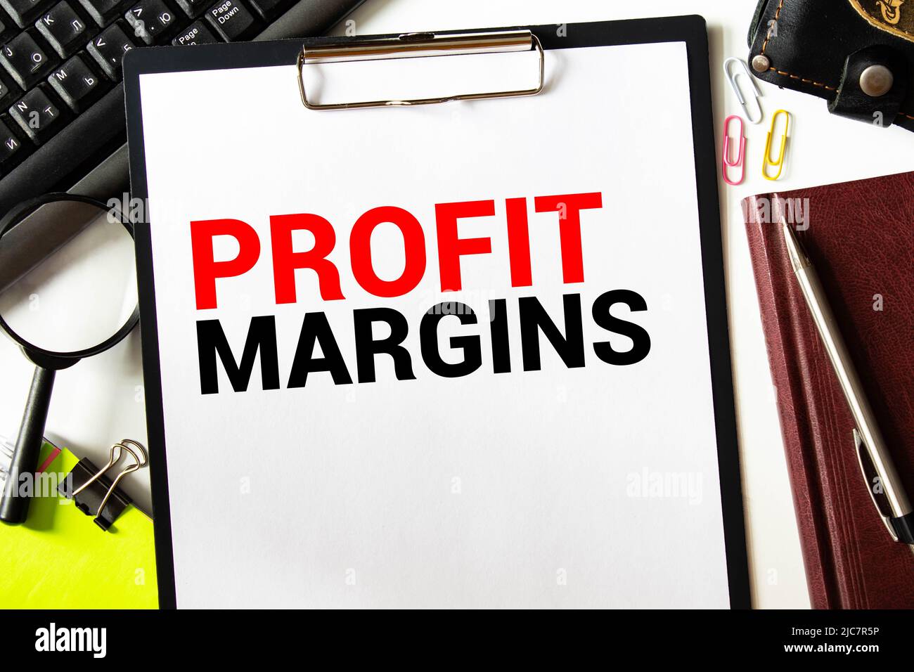 Closeup on businessman holding a card with text PROFIT MARGIN, business ...