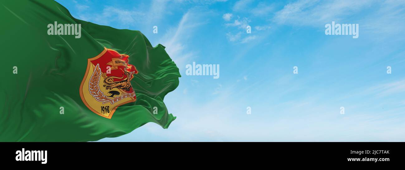 official flag of East Nusa Tenggara Indonesia at cloudy sky background ...