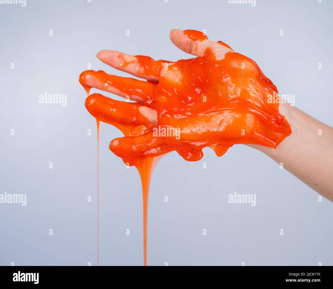 Red slime flowing down from a woman's hand on a white background Stock ...