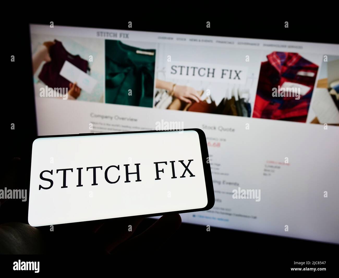 Person holding mobile phone with logo of American styling company ...