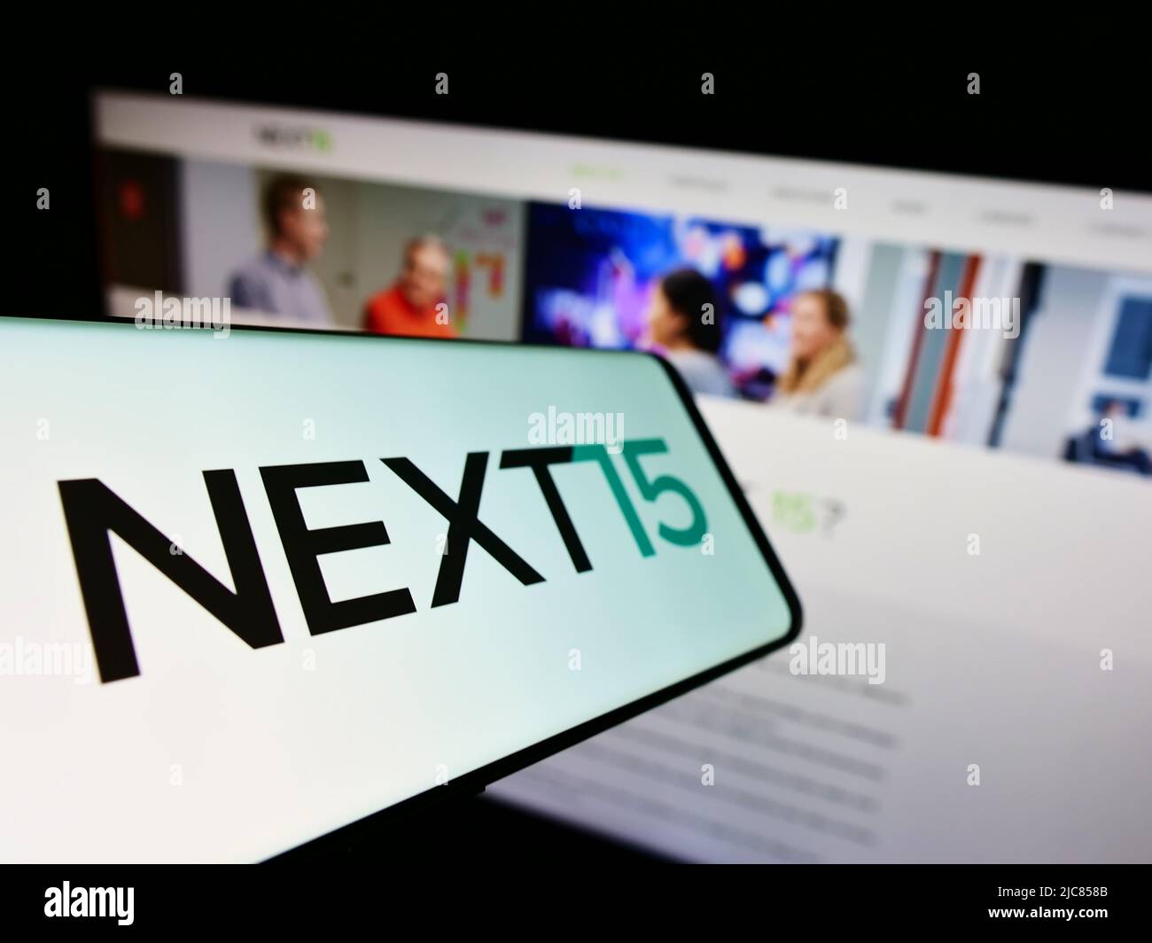 Cellphone with logo of company Next Fifteen Communications Group plc on ...