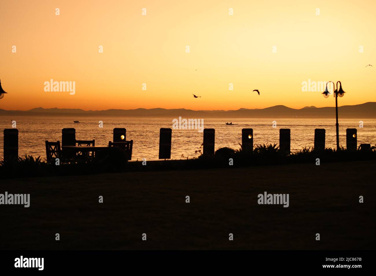 Cape Town sunset ocean view, VA Waterfront, Houts Bay, yellow sky and ...