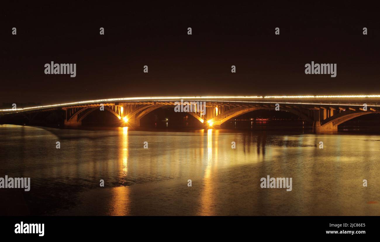 Lights of city bridge illumination over city street at night Stock ...
