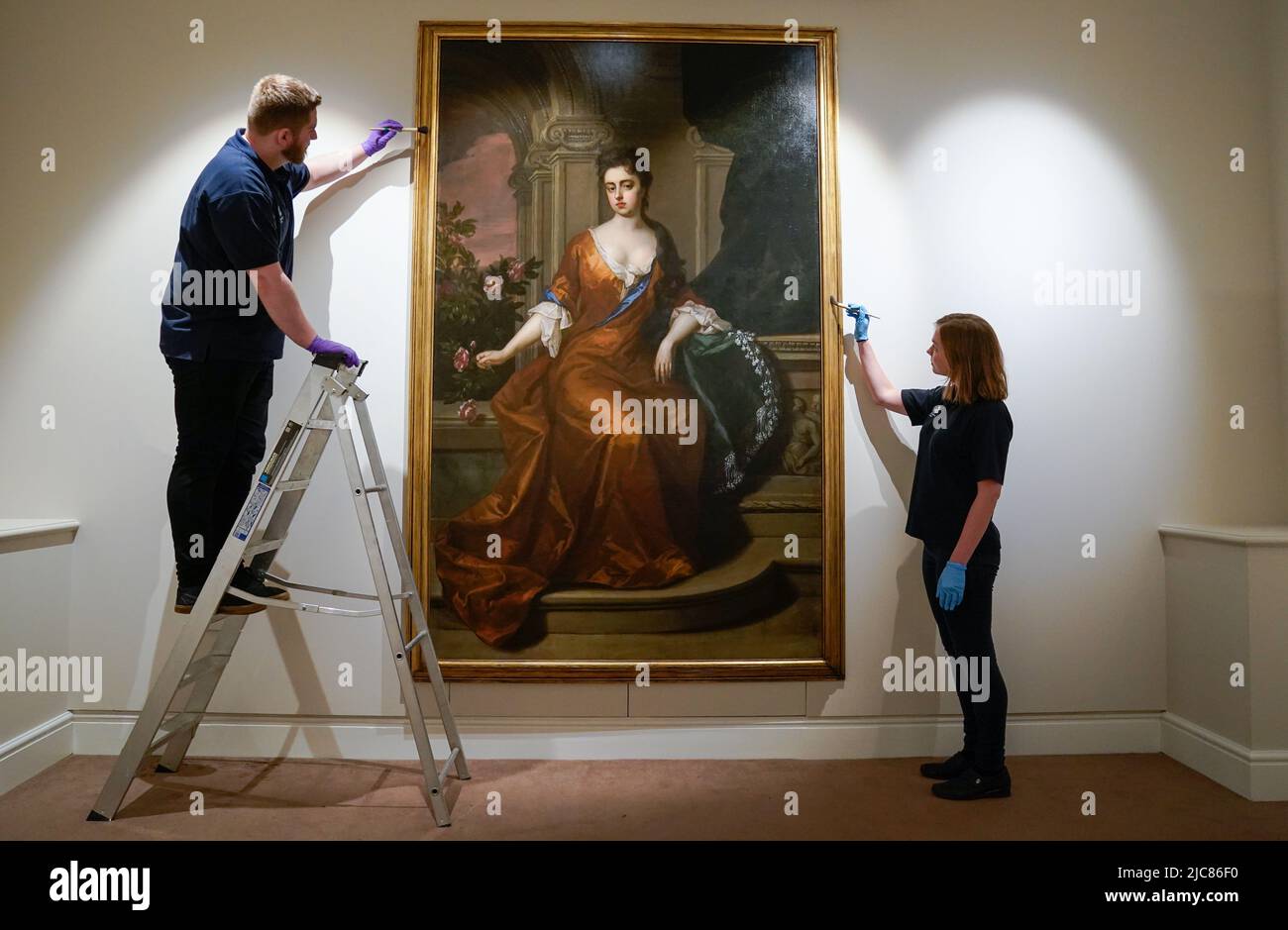 National Trust Collection Assistants clean the frame of a painting of ...