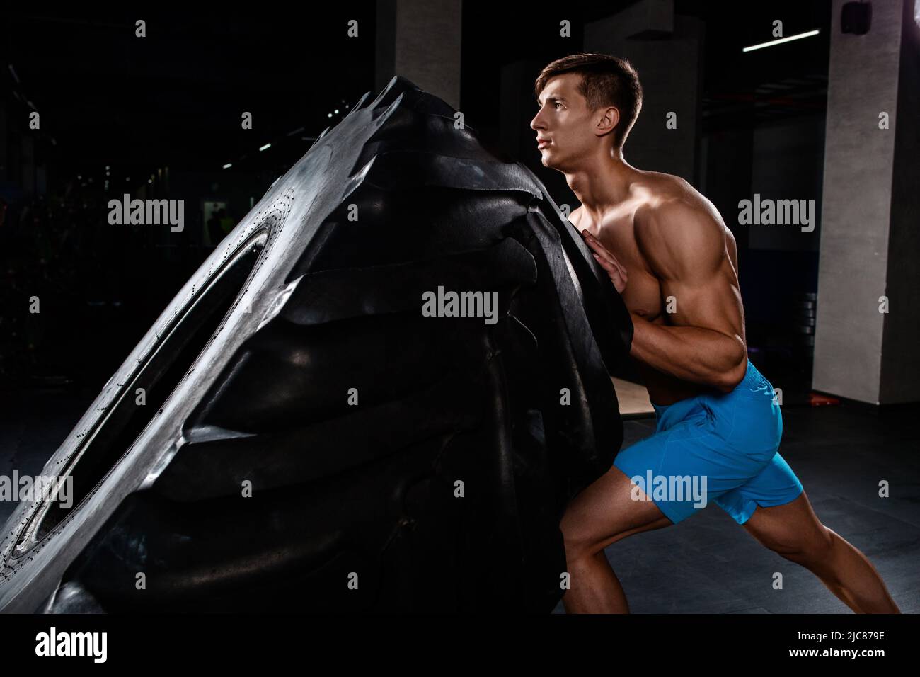 Crossfit training - man flipping tire in gym Stock Photo - Alamy