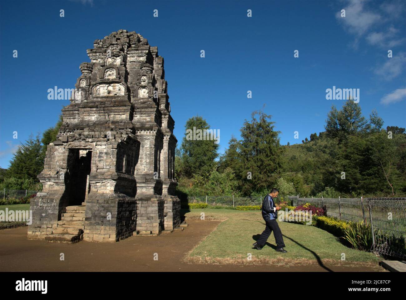 A man walking away from Bima temple, an ancient Hindu temple on Dieng ...