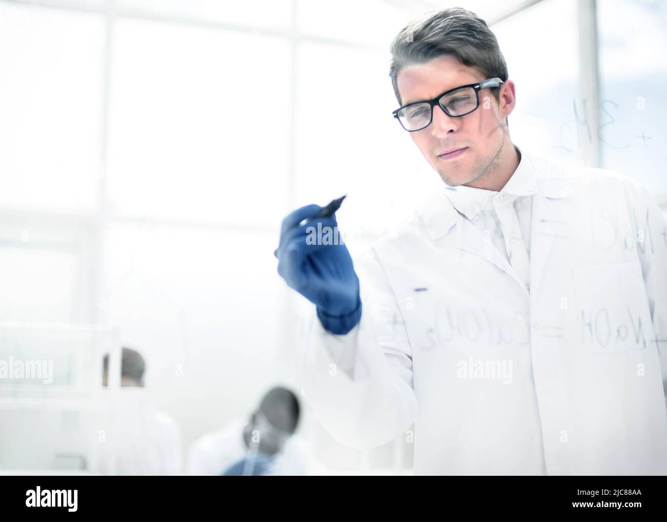 successful scientist writes a formula on a glass Board .photo with copy ...