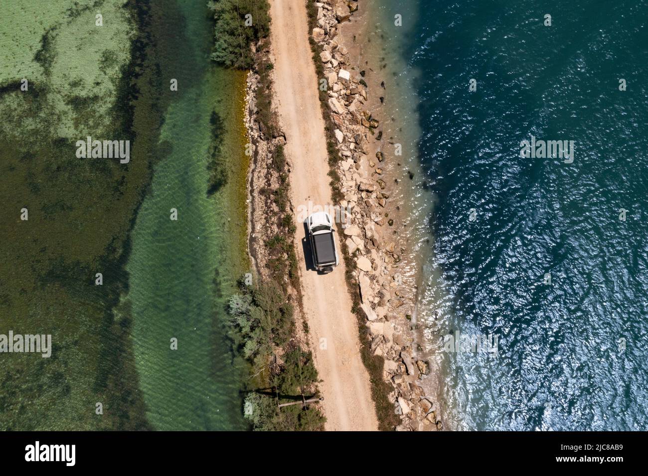 Aerial view of an off-road vehicle on an expedition through a lagoon ...