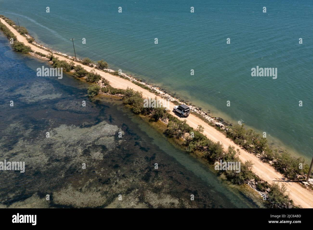 Aerial view of an off-road vehicle on an expedition through a lagoon ...