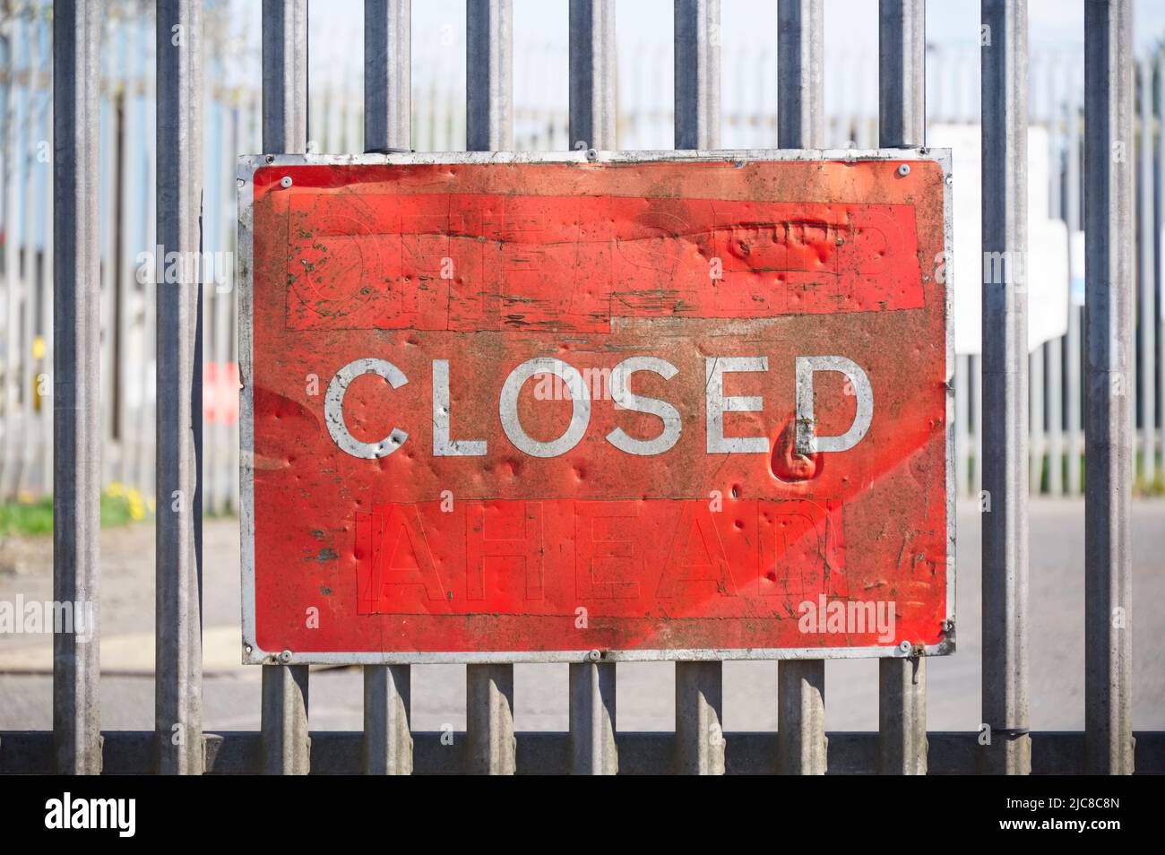 Closed sign at industrial estate entrance gate Stock Photo - Alamy