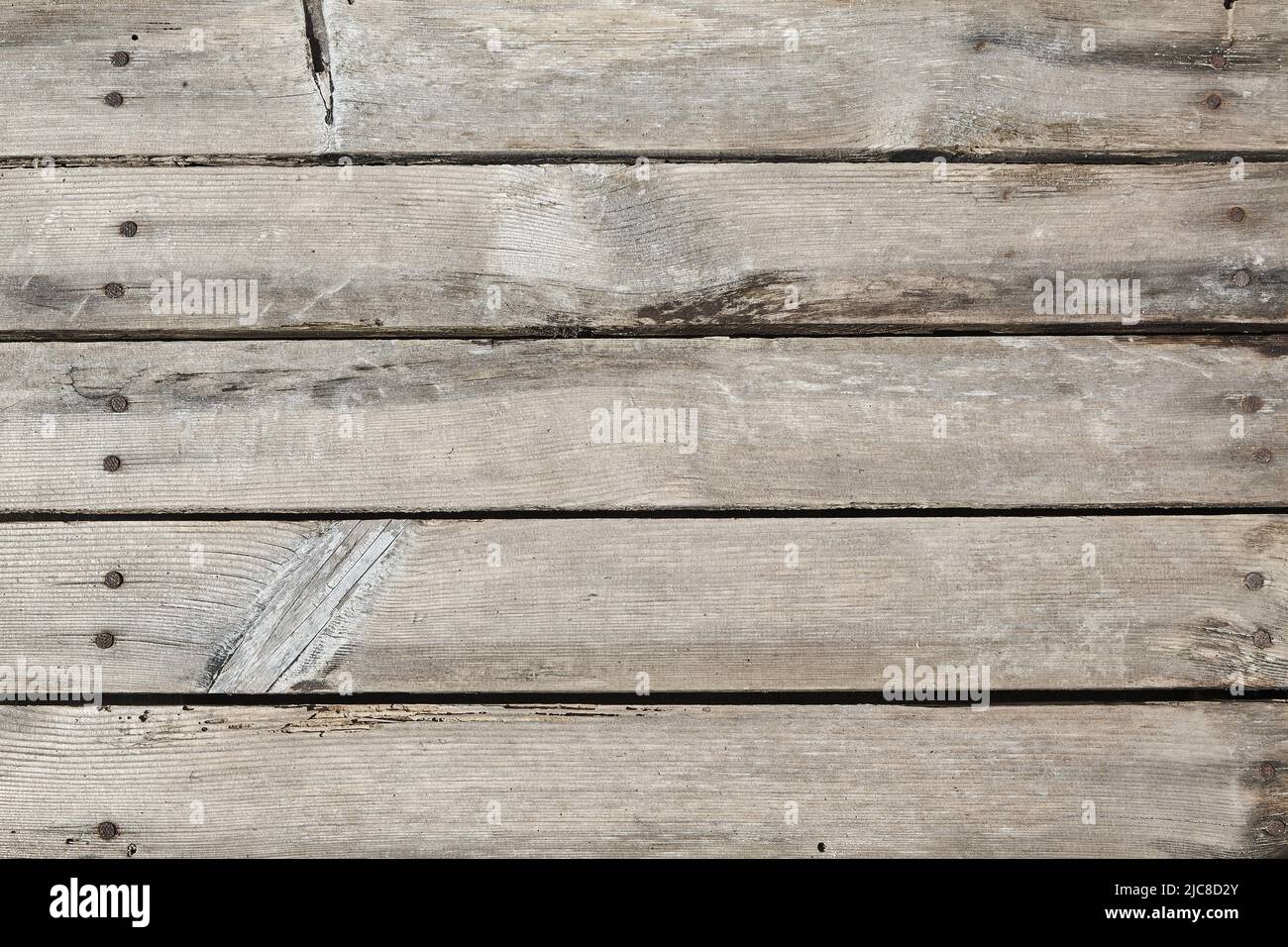 Wooden floor made of old boards with knots and cracks with rusty nails ...