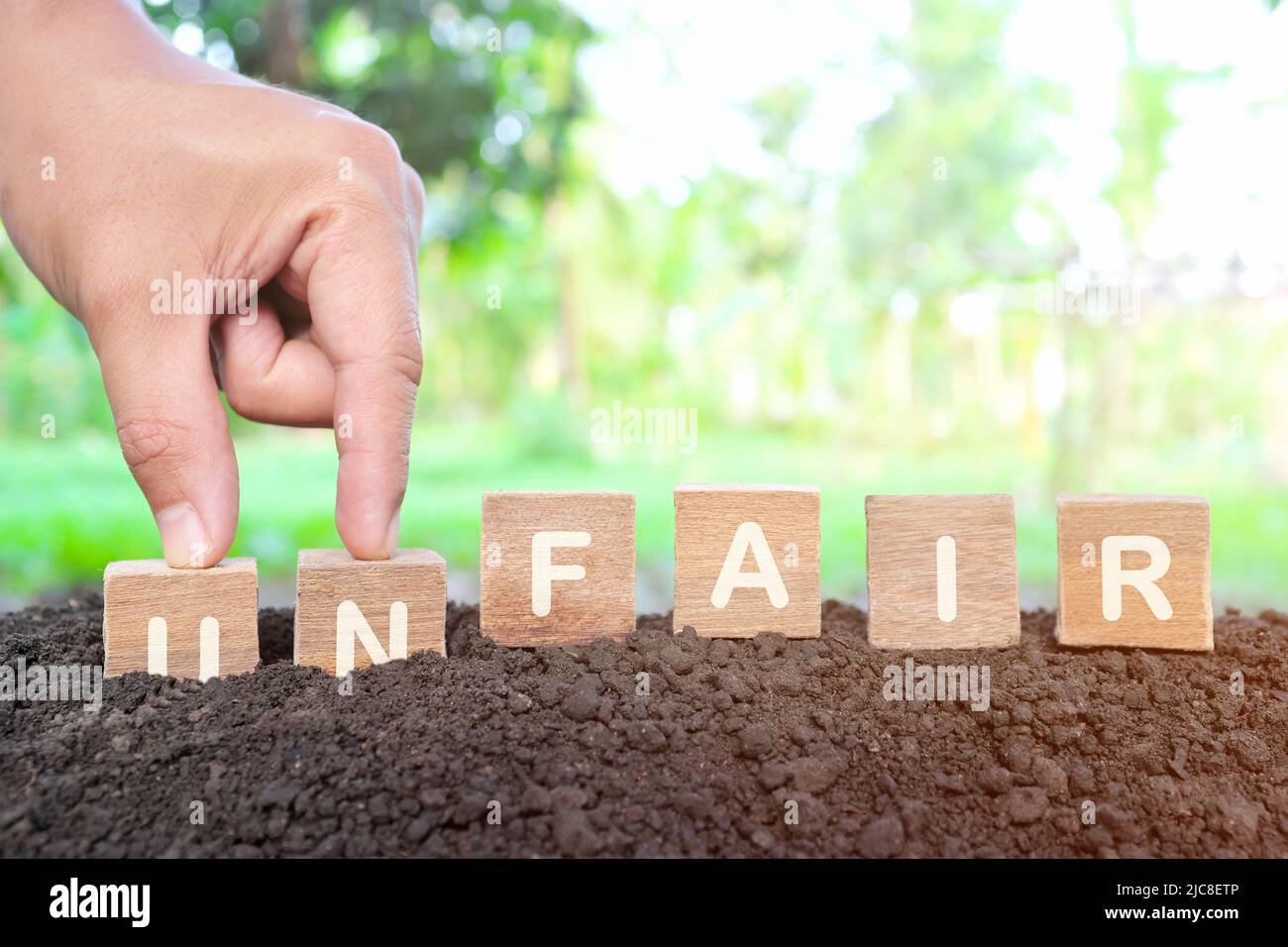 Justice and fairness concept. Hand changing unfair to fair word on ...