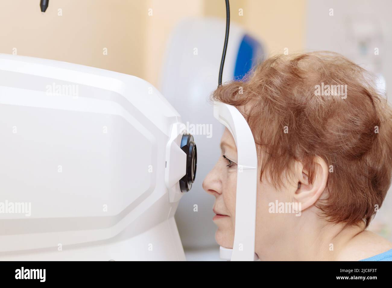 An adult woman at an ophthalmologist's appointment checks her vision on ...