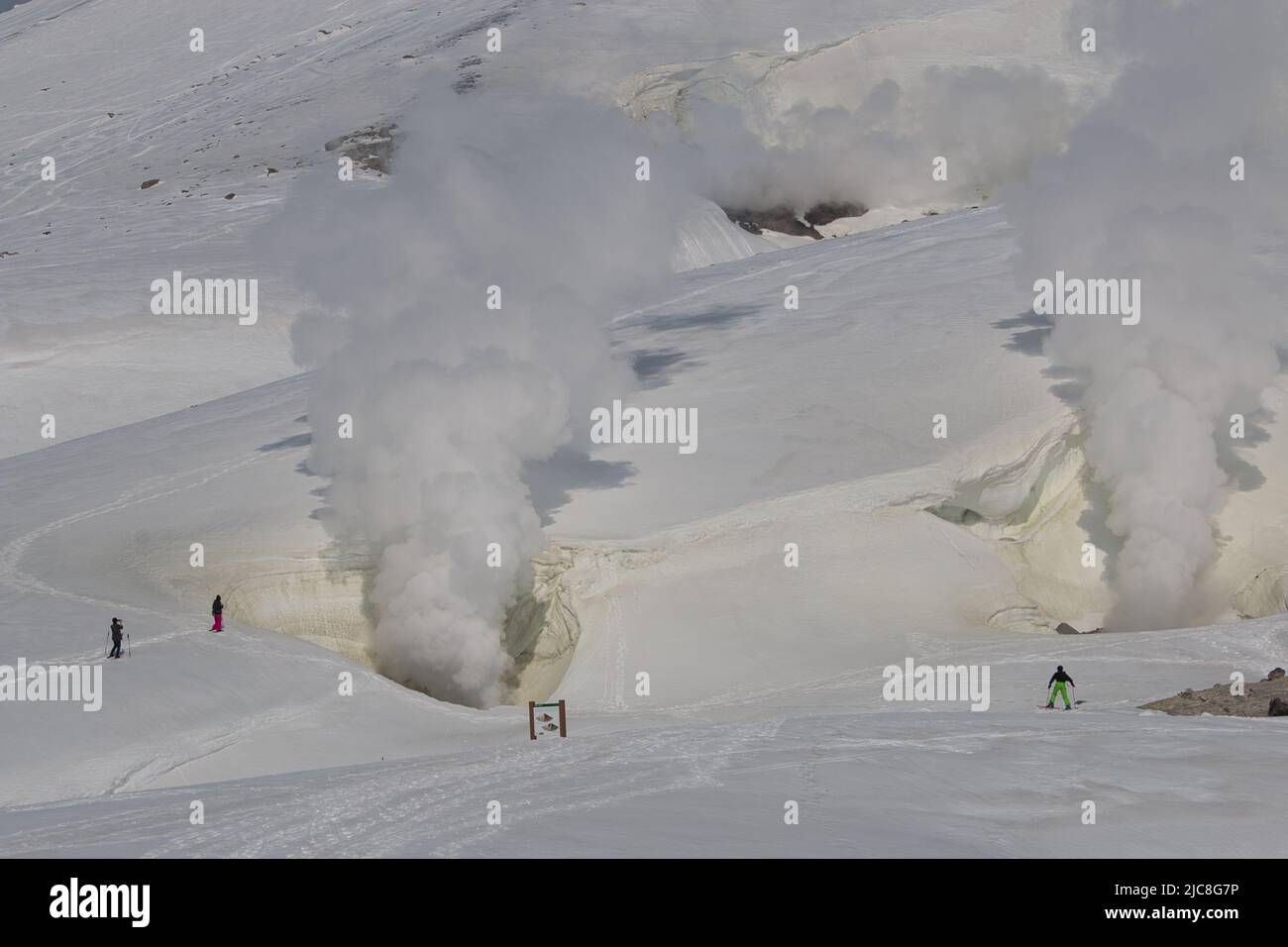 Tourists standing next to volcanic vents emitting smoke Stock Photo - Alamy