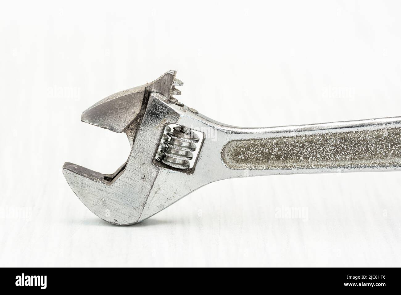 Adjustable metal wrench. Steel adjustable wrench on white wooden ...