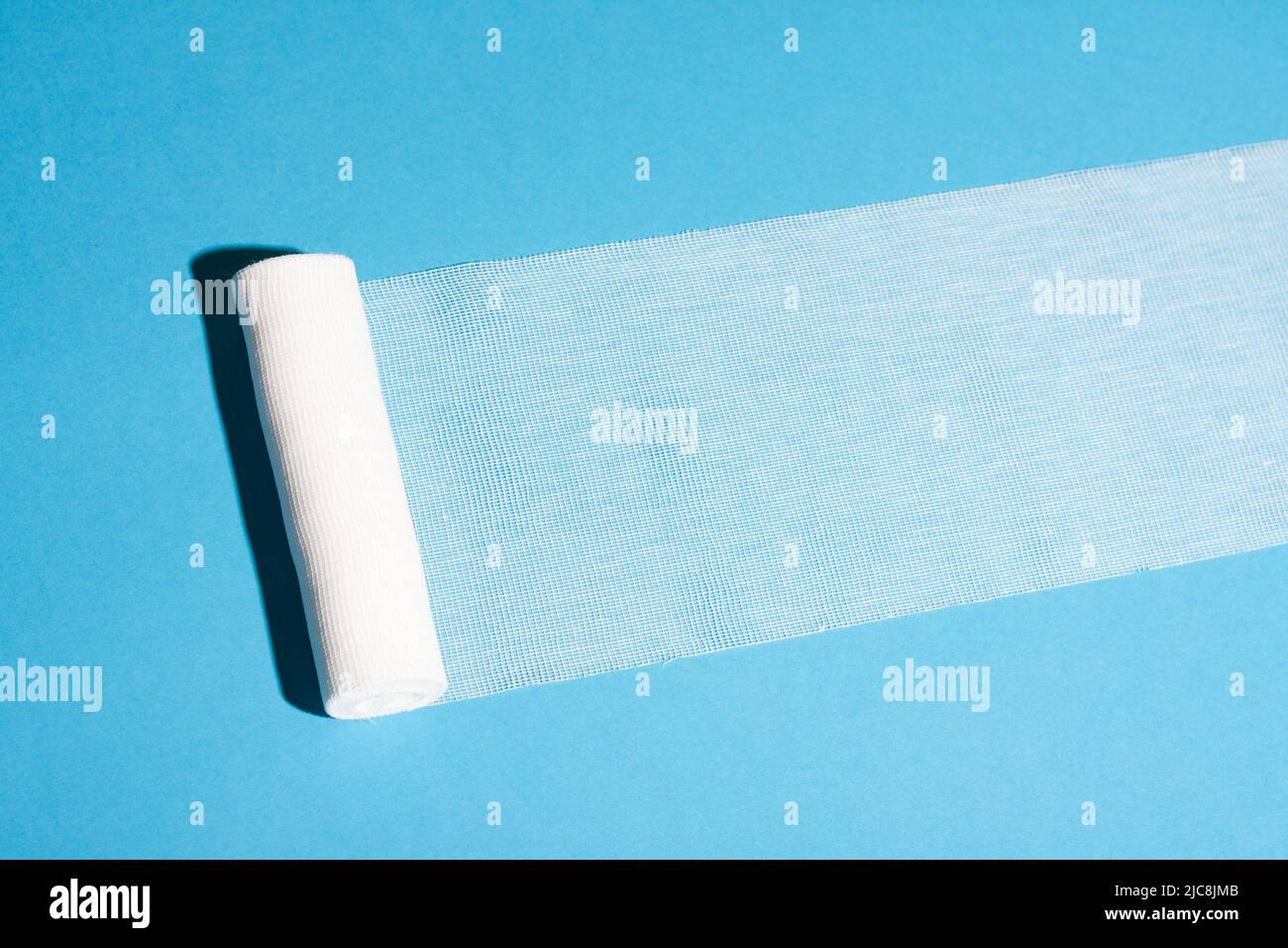 Sterile bandage roll unwound on blue background Stock Photo - Alamy