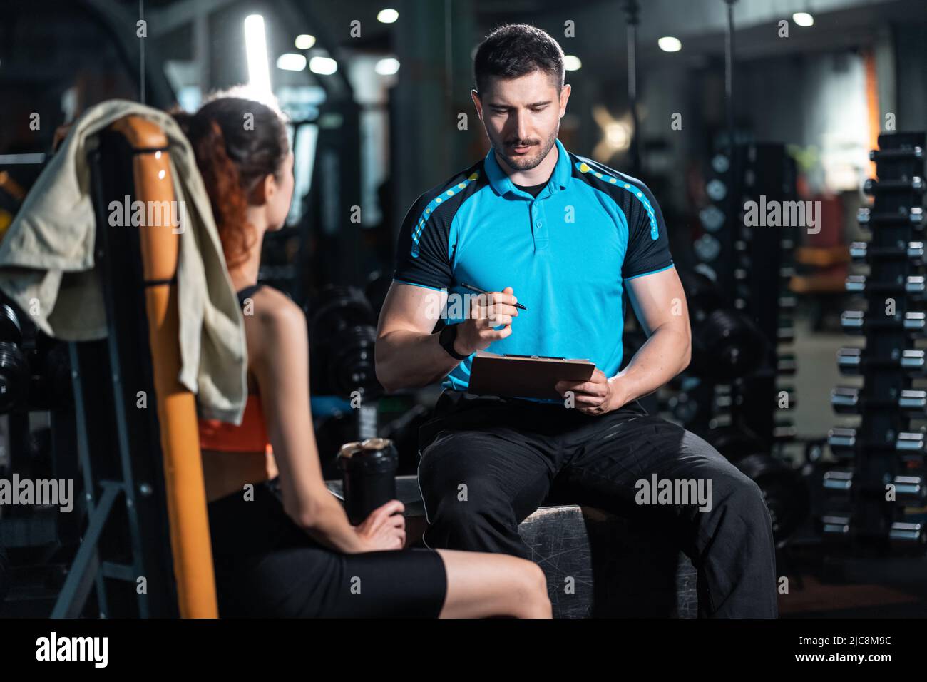 young personal trainer man talking with woman athlete and plan workout ...