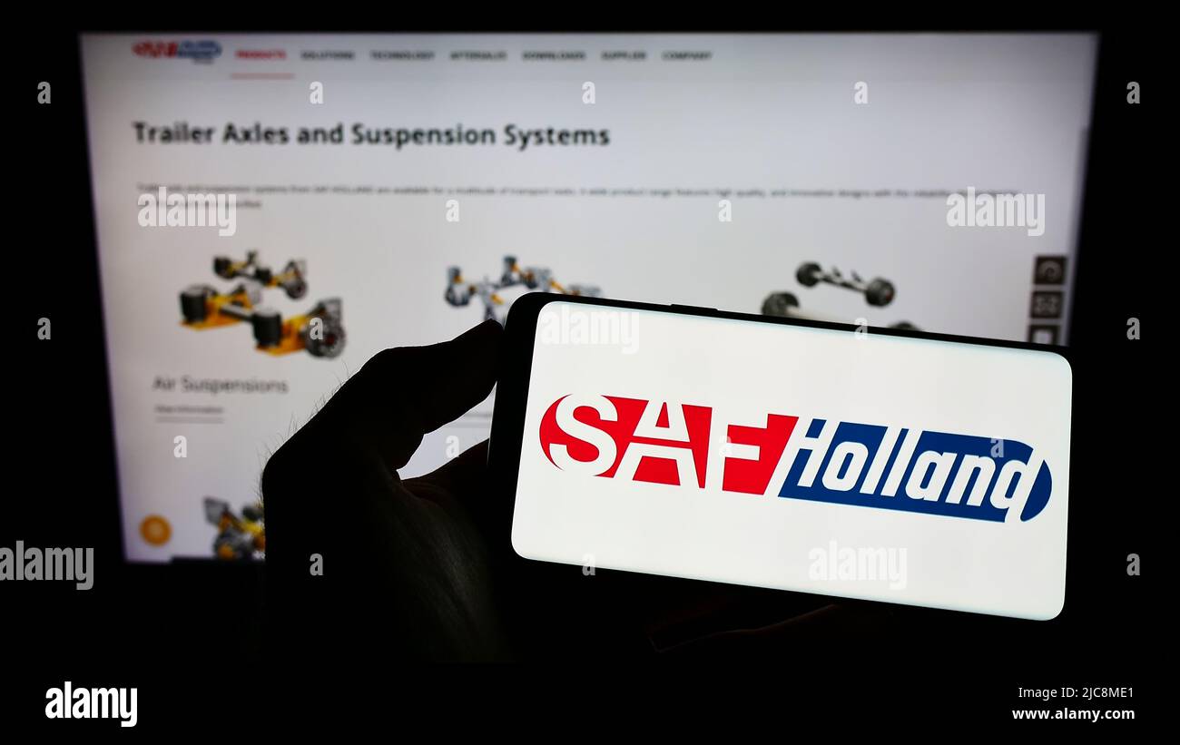 Person holding mobile phone with logo of German automotive company SAF ...