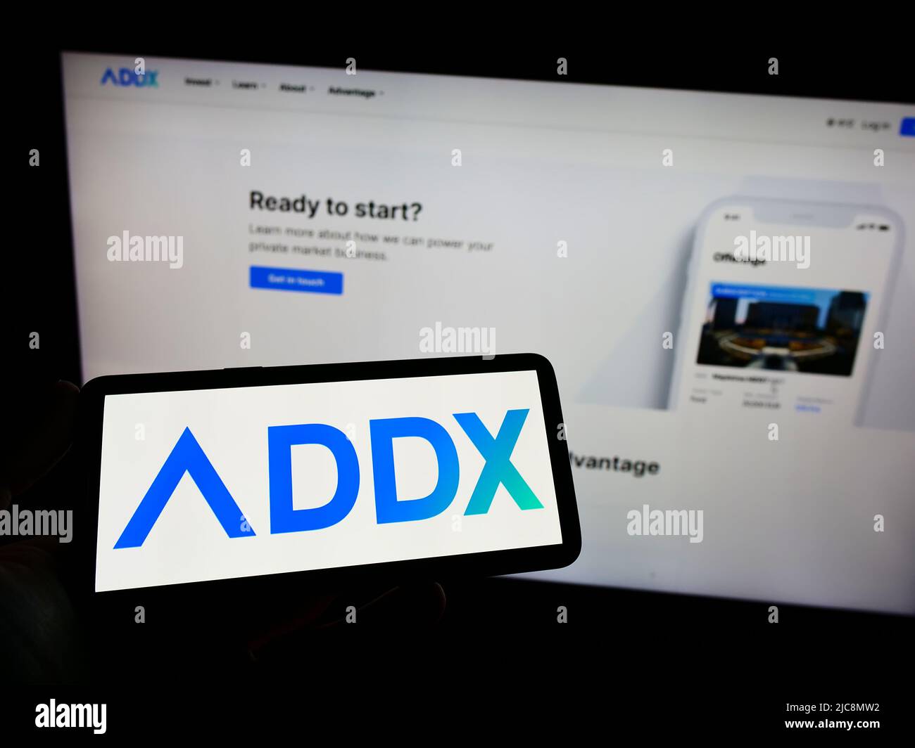 Person holding smartphone with logo of fintech company ICHX Tech Pte ...