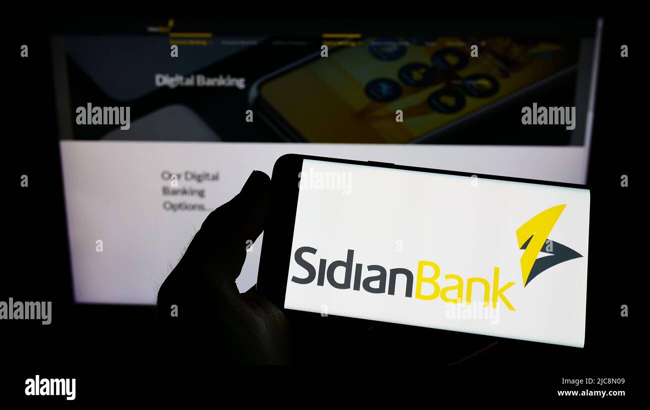 Person holding smartphone with logo of Kenyan financial company Sidian ...