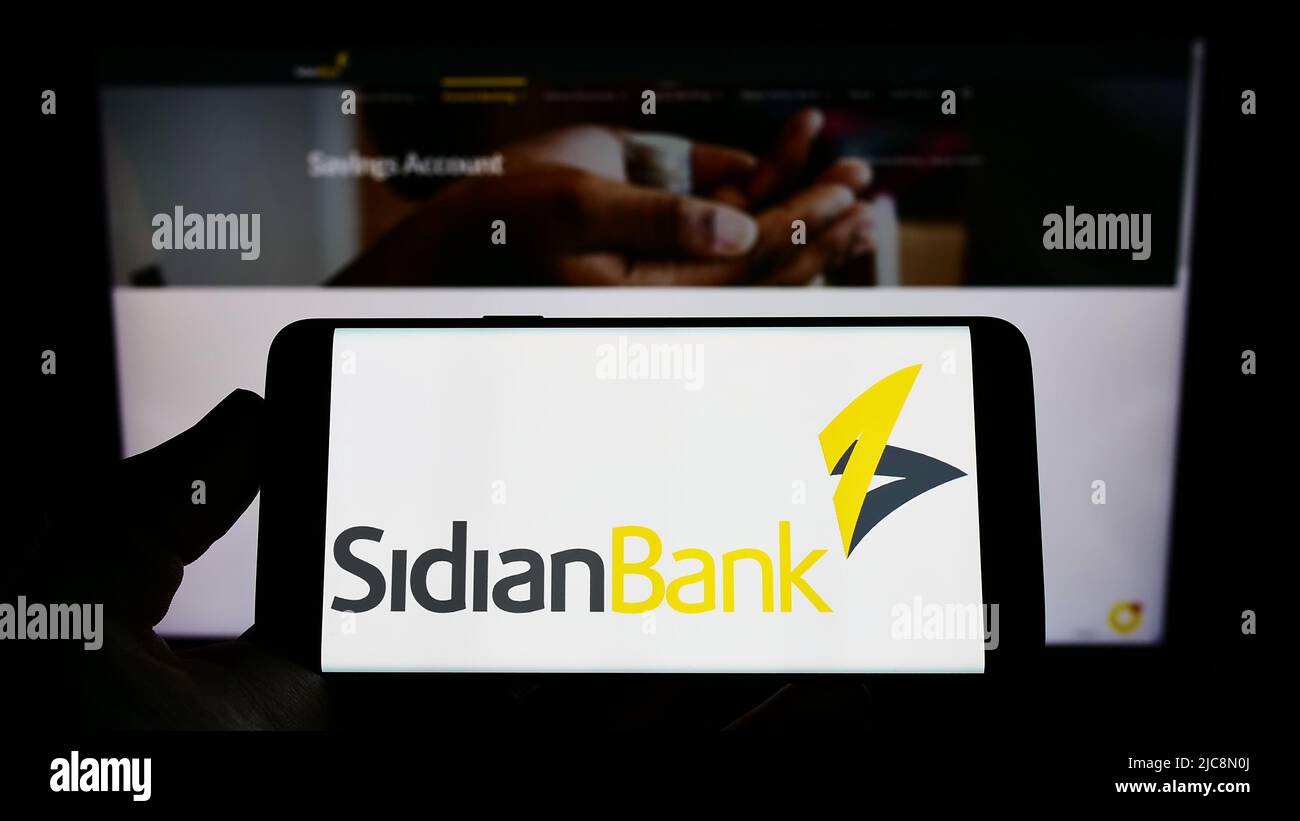 Person holding mobile phone with logo of Kenyan financial company ...