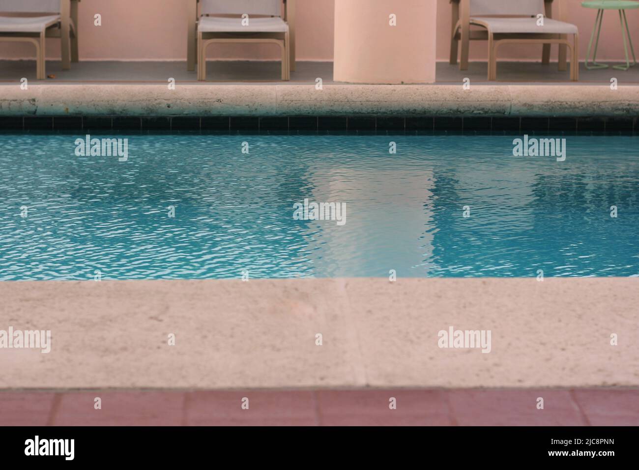 Simple and plain columns reflecting in the surface of the swimming pool ...