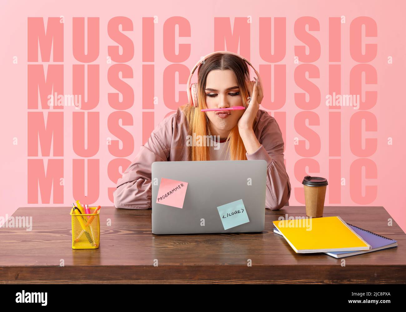 Transgender programmer with laptop listening to music on pink ...