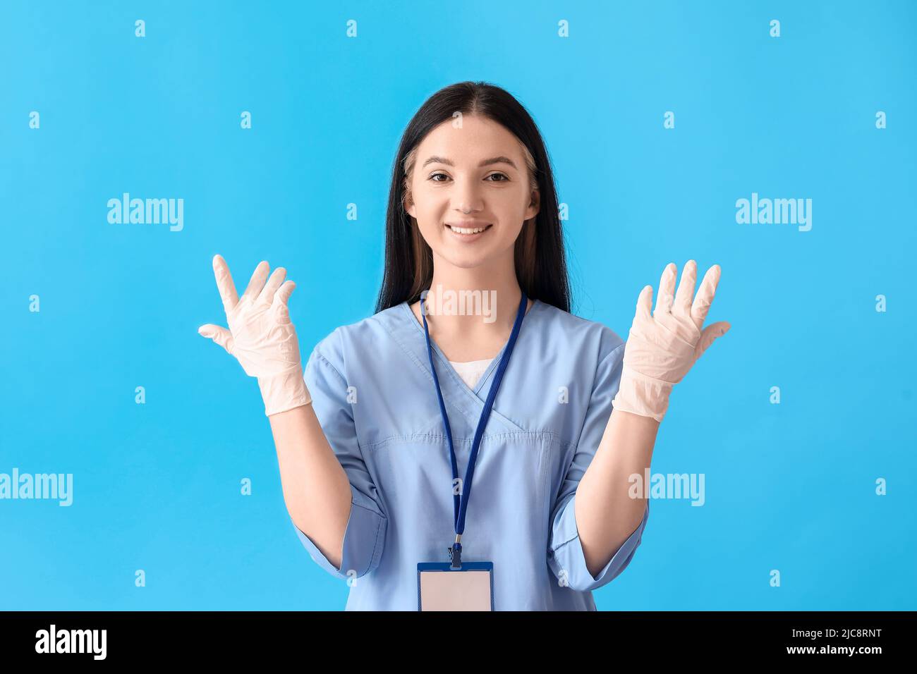 Female medical assistant with gloves on blue background Stock Photo - Alamy