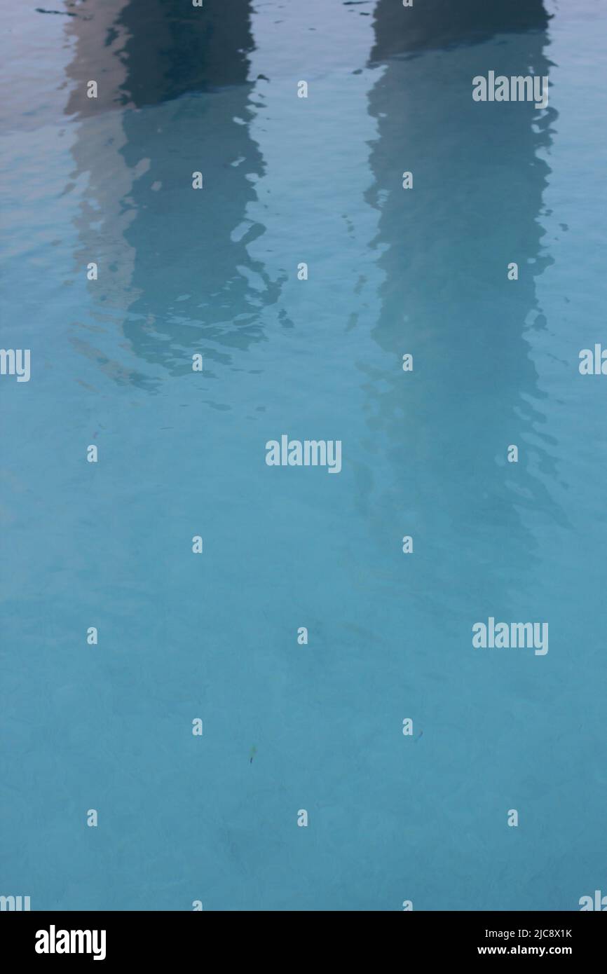 Simple and plain columns reflecting in the surface of the swimming pool ...