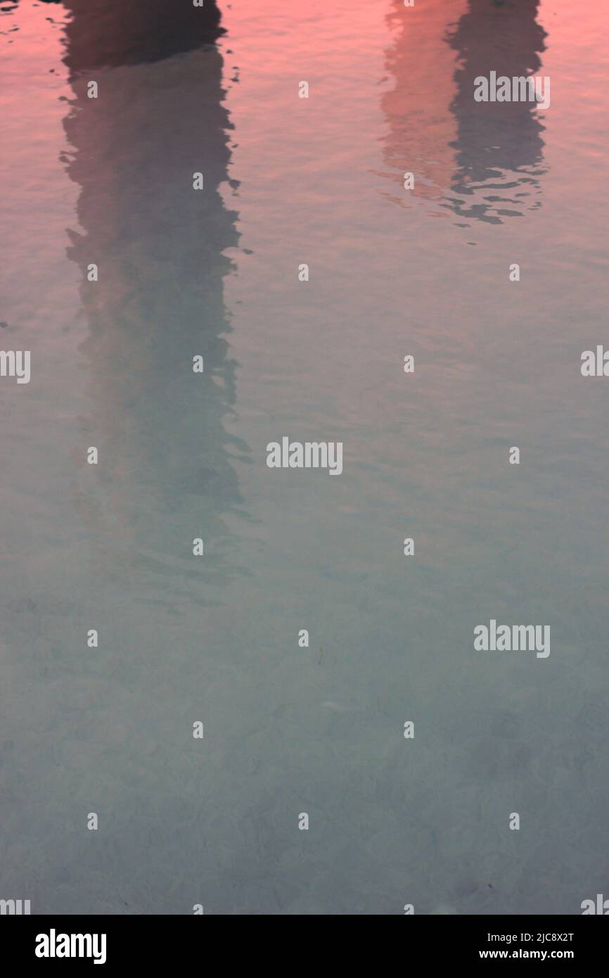 Simple and plain columns reflecting in the surface of the swimming pool ...