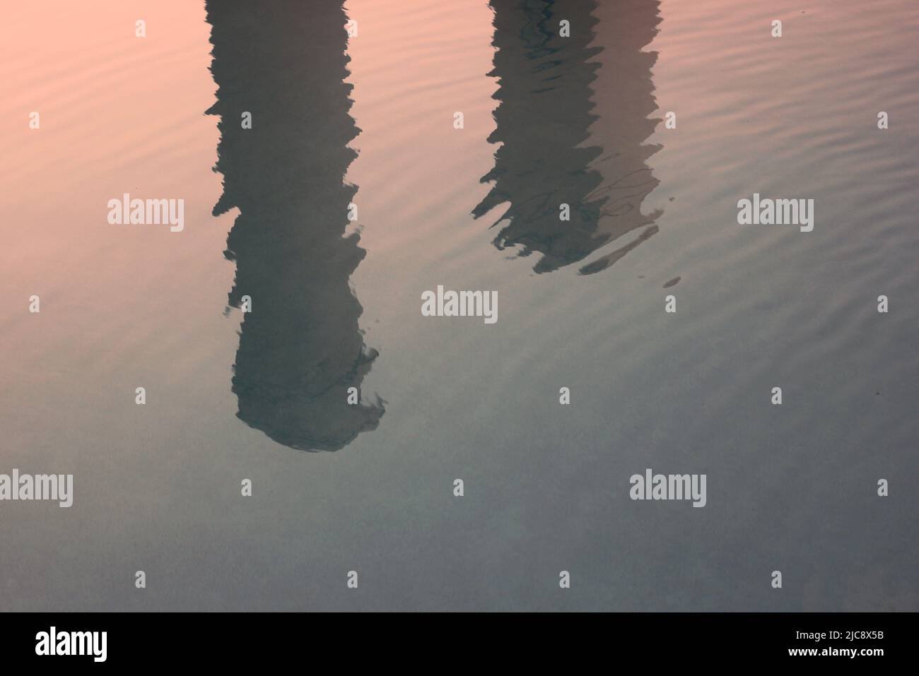 Simple and plain columns reflecting in the surface of the swimming pool ...