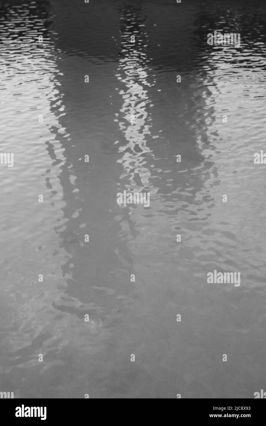 Simple and plain columns reflecting in the surface of the swimming pool ...