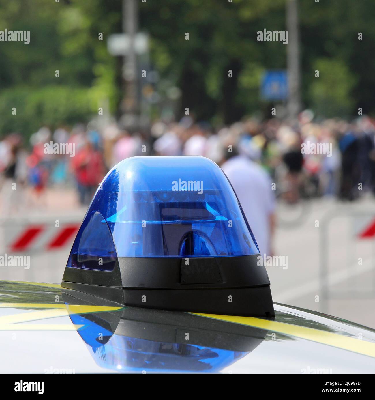 blue light siren of police car and unrecognizable people during riot ...