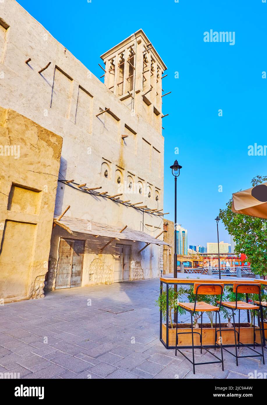 The outdoor cafe terrace on the street with historic adobe house ...