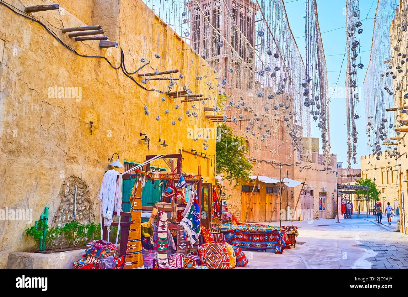 The carpet market in front of the old adobe wall of historic house in ...