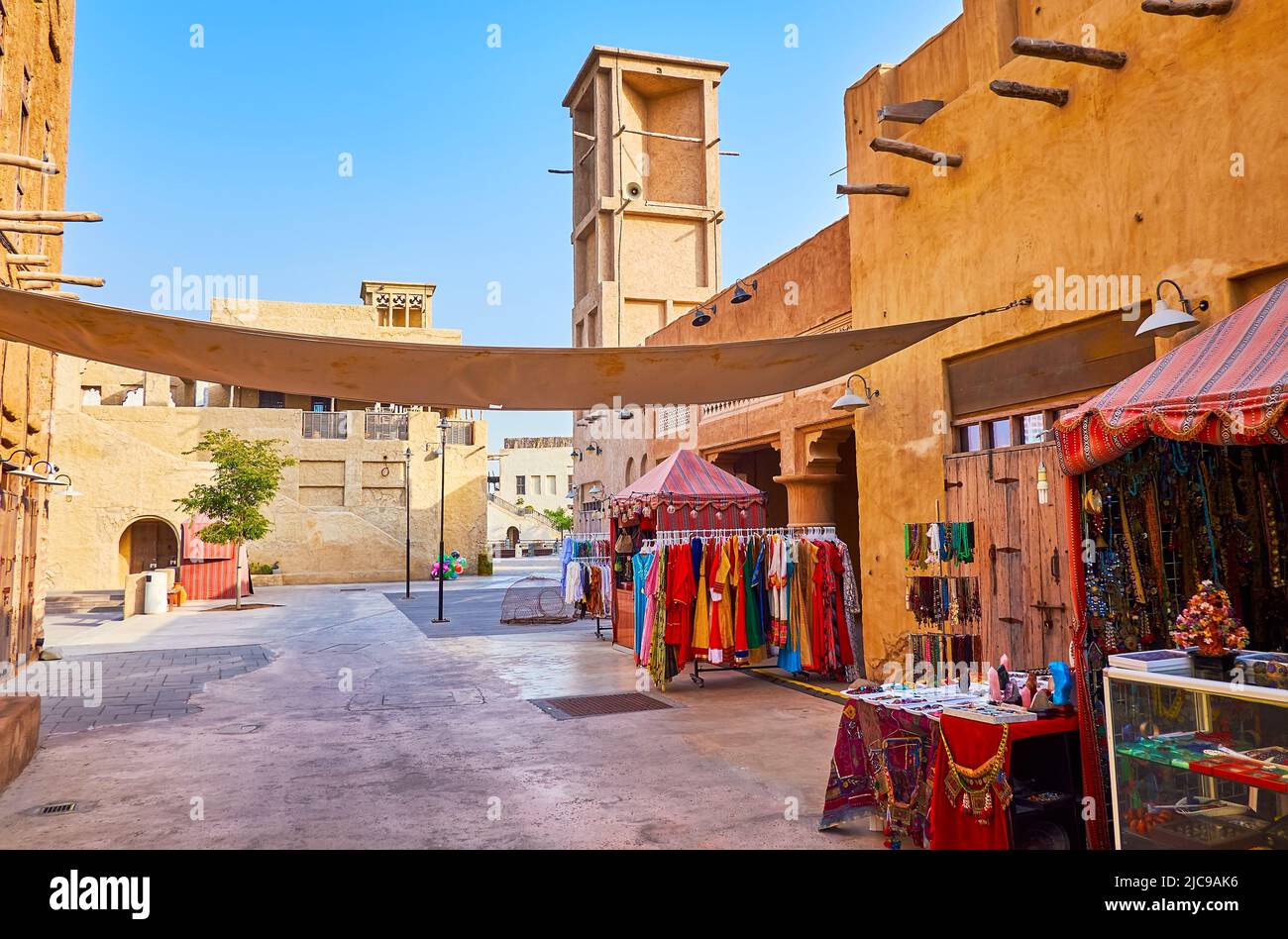 The narrow street of Dubai Heritage Village, lined with old clay houses ...