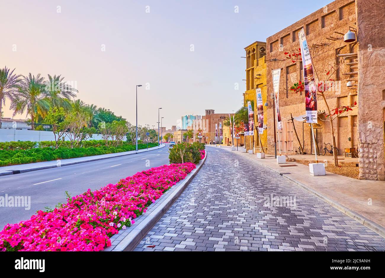 Walk down the scenic Al Seef street with a view on traditional adobe Arabic housing, colorful ...
